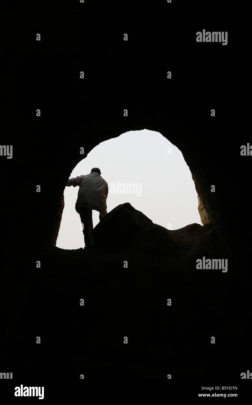 dark figure man silhouette standing inside dark cave Stock Photo - Alamy