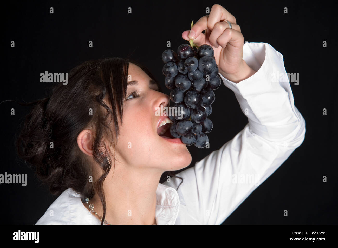 Woman eating grapes Stock Photo - Alamy