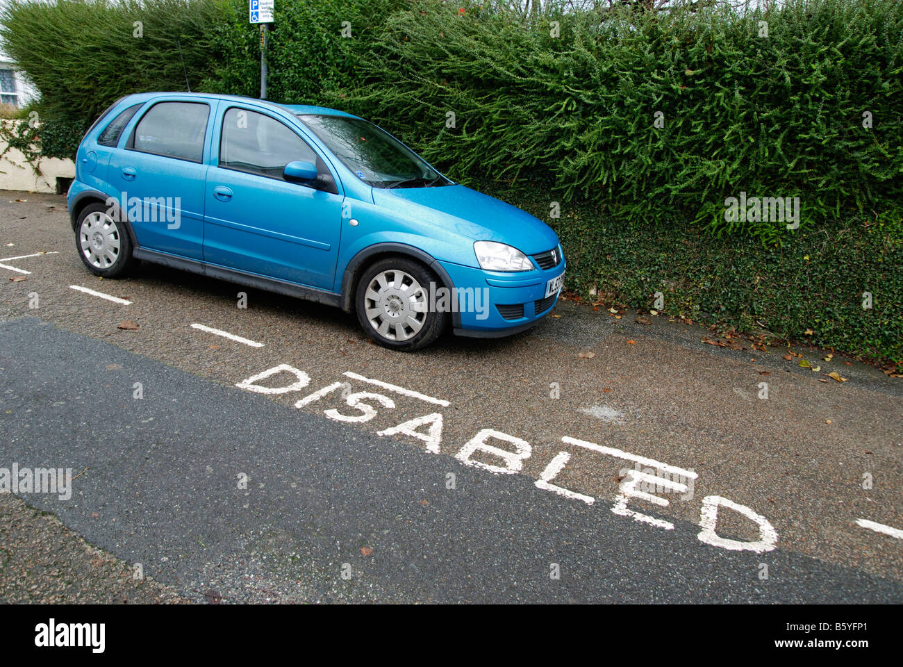 a blue car parked in a disabled vehicle bay Stock Photo - Alamy