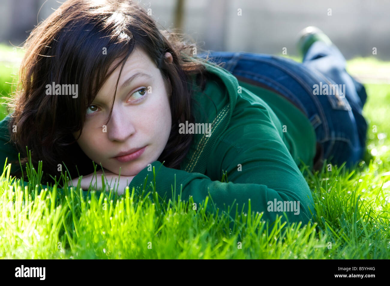 Young beautiful girl laying in the grass Stock Photo - Alamy