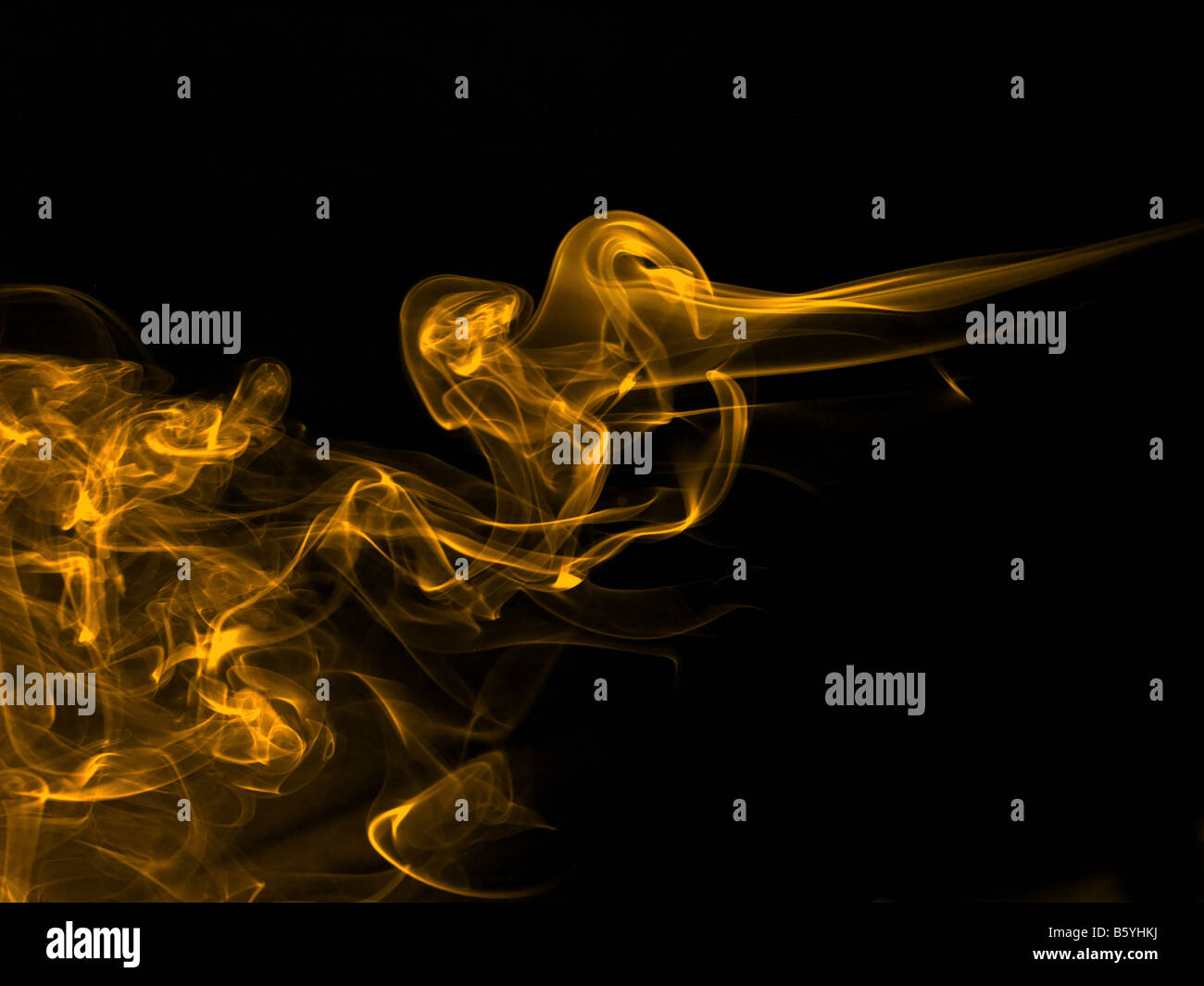 Golden colored smoke on a black backround Stock Photo - Alamy
