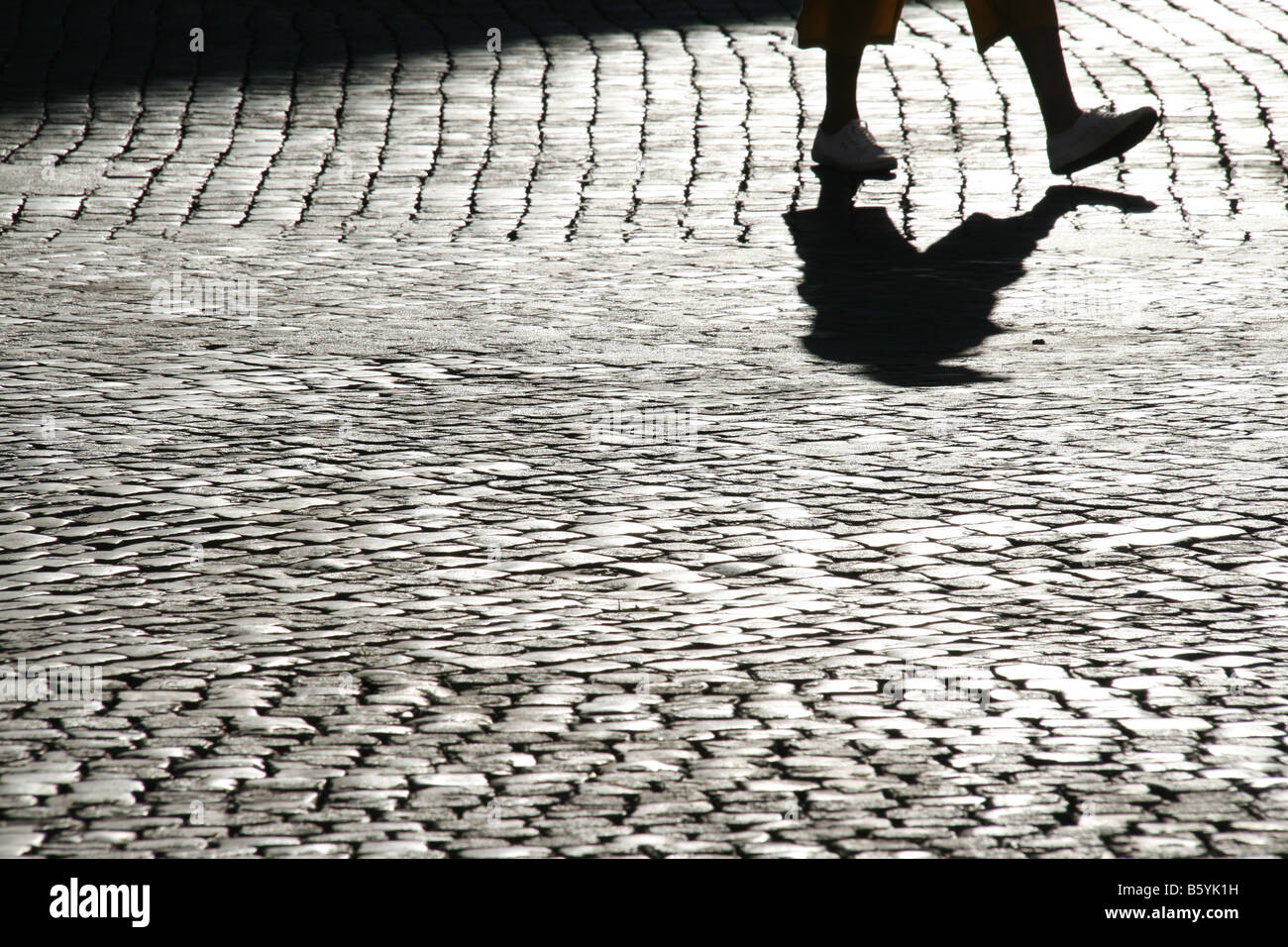 shadow person feet legs walking in street in town Stock Photo - Alamy