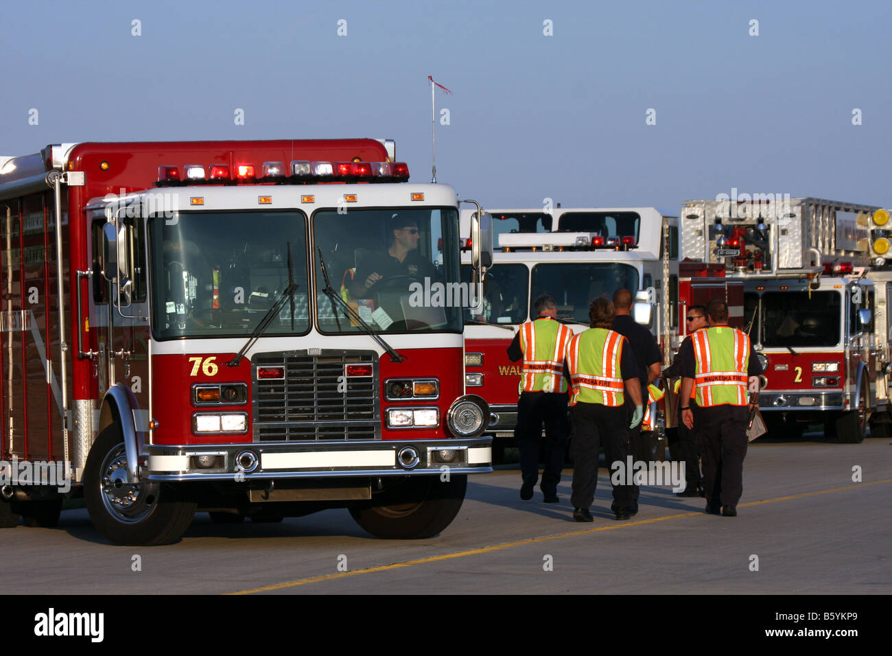 Multiple fire trucks and firemen leaving an emergency scene Stock Photo ...