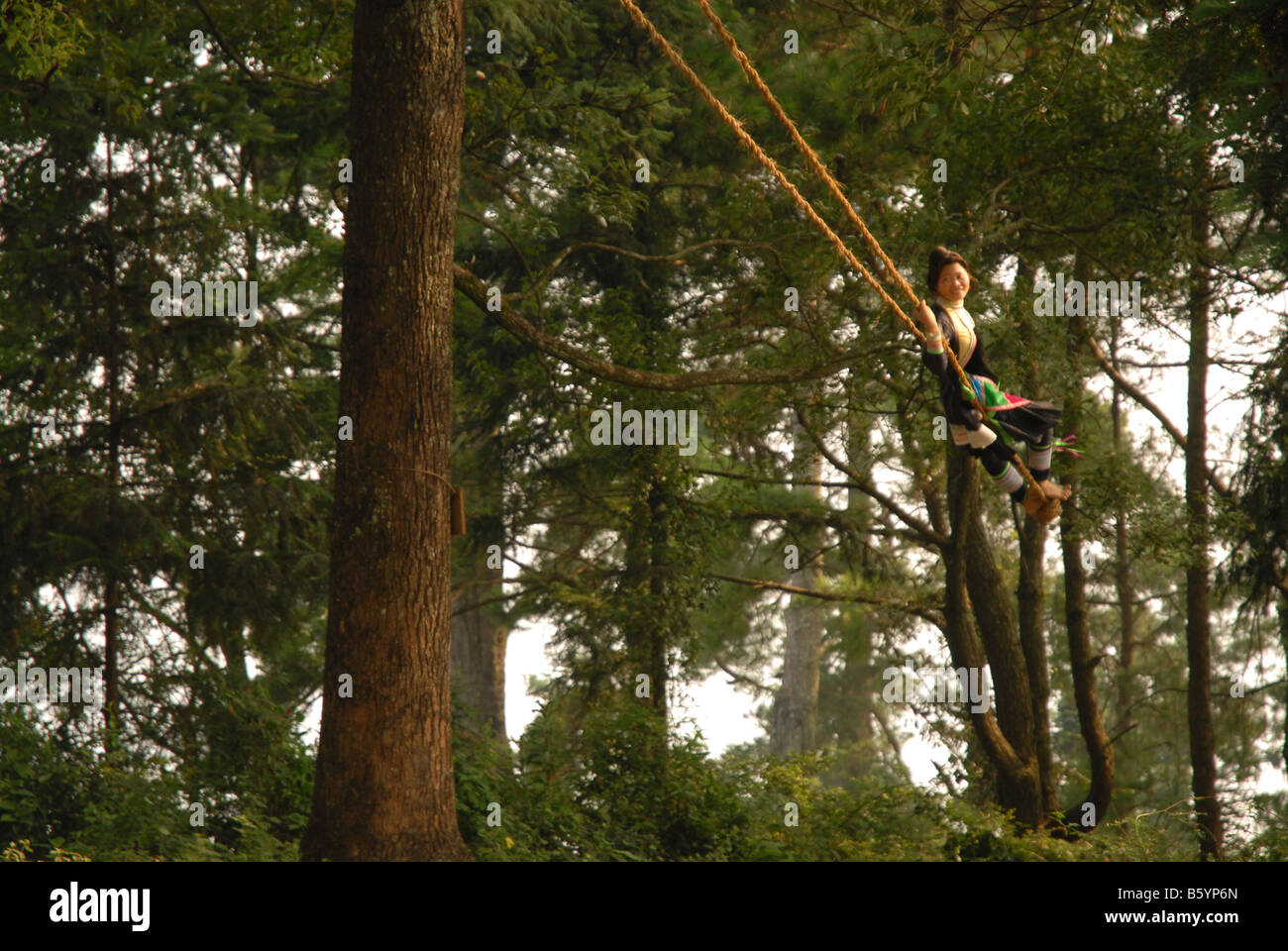 A girl on a swing in rural Guizhou Province, China. She is a member of ...