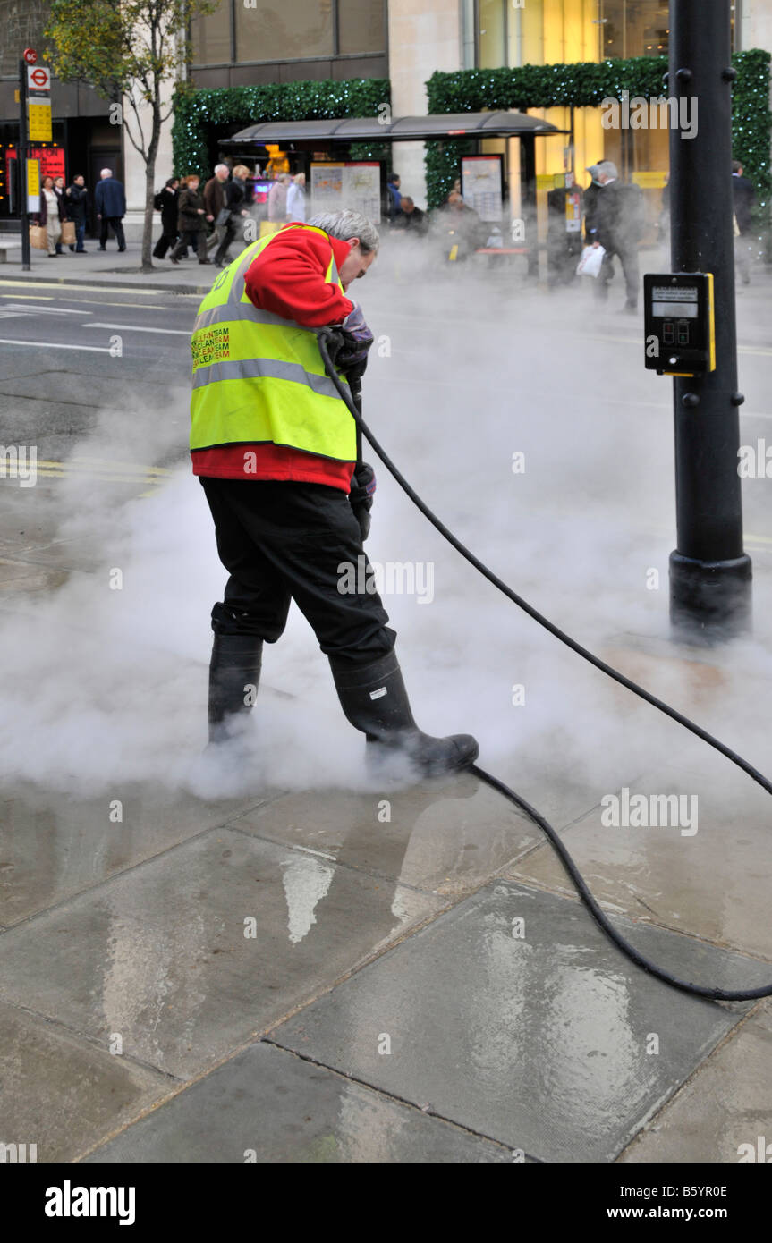 Workman high visibility vest using pressure washer steam clean lance to ...