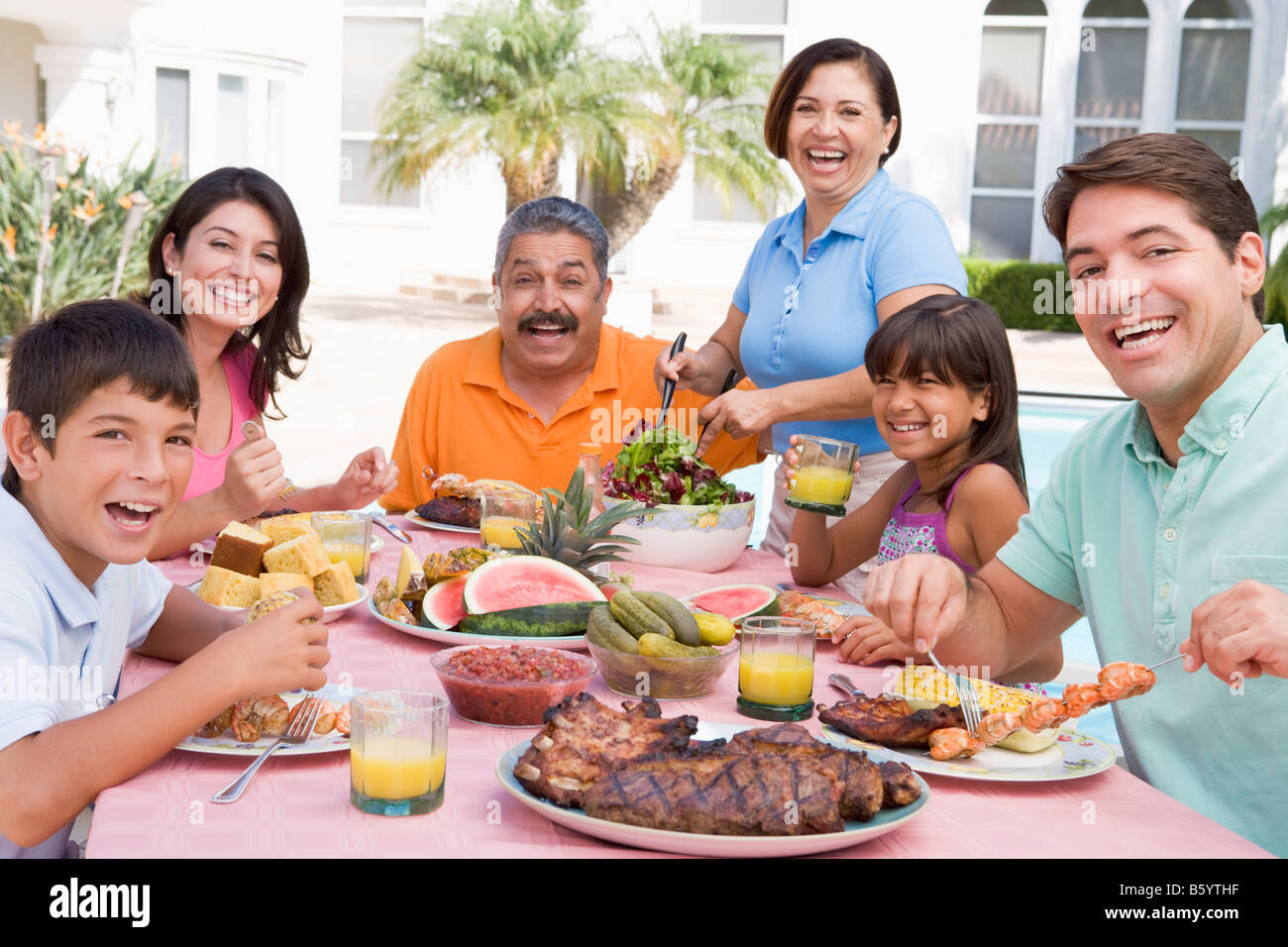 Family Enjoying A Barbeque Stock Photo - Alamy