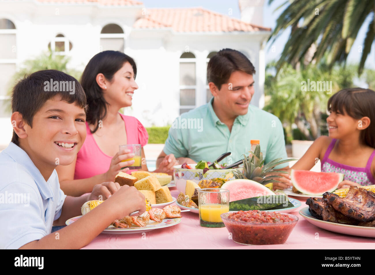 Family Enjoying A Barbeque Stock Photo - Alamy