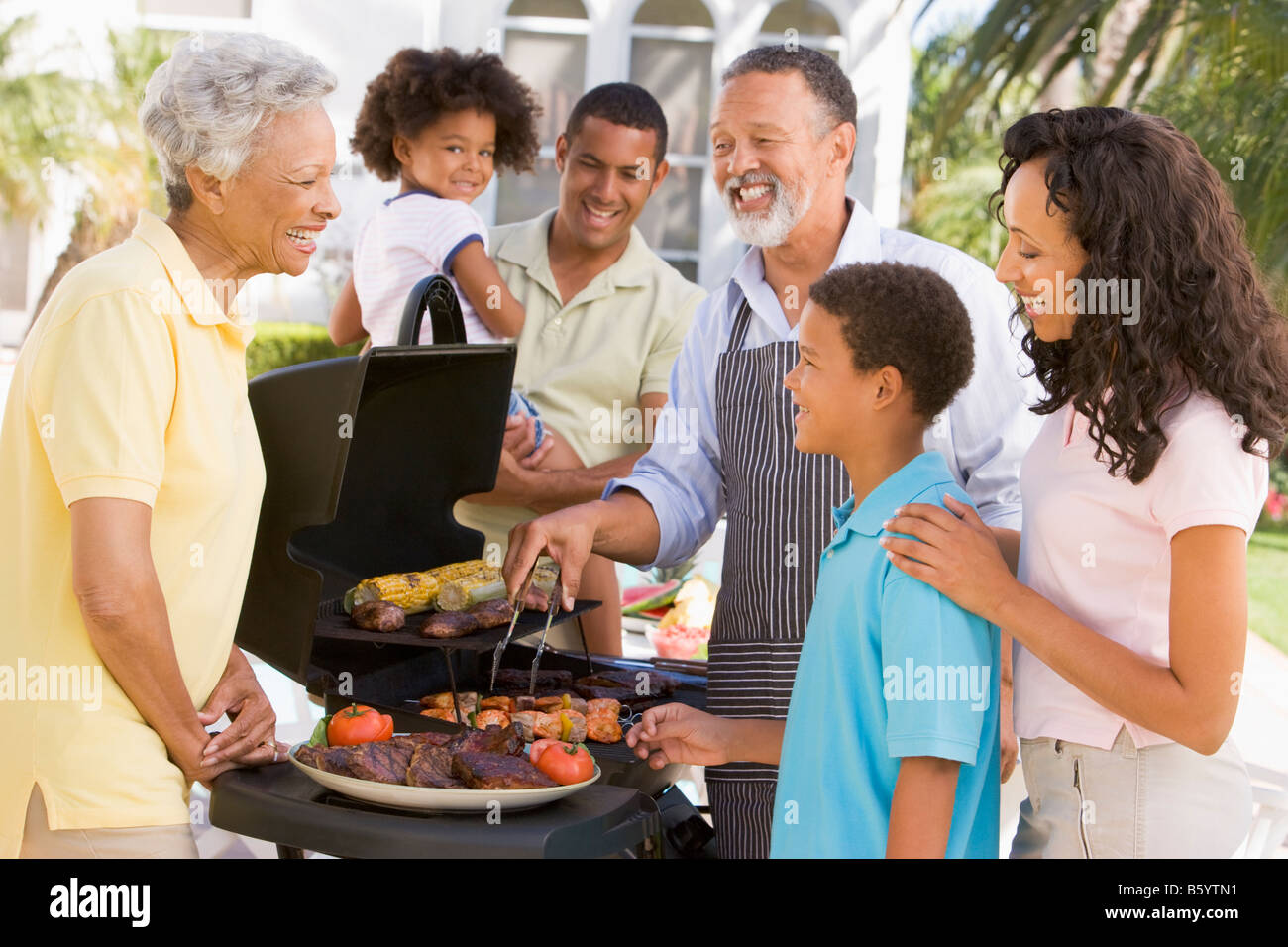 Family Enjoying A Barbeque Stock Photo - Alamy