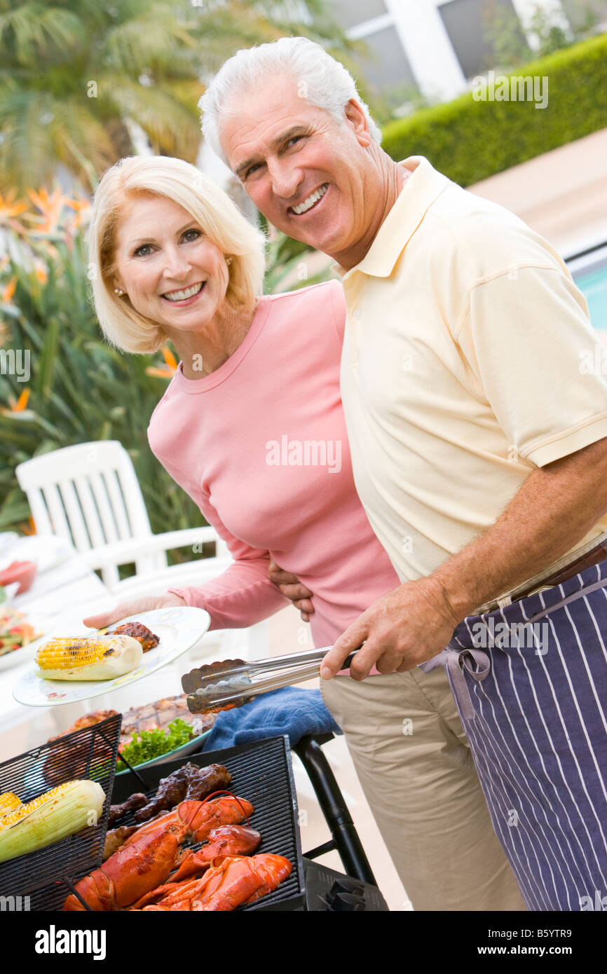 Couple Cooking On A Barbeque Stock Photo - Alamy