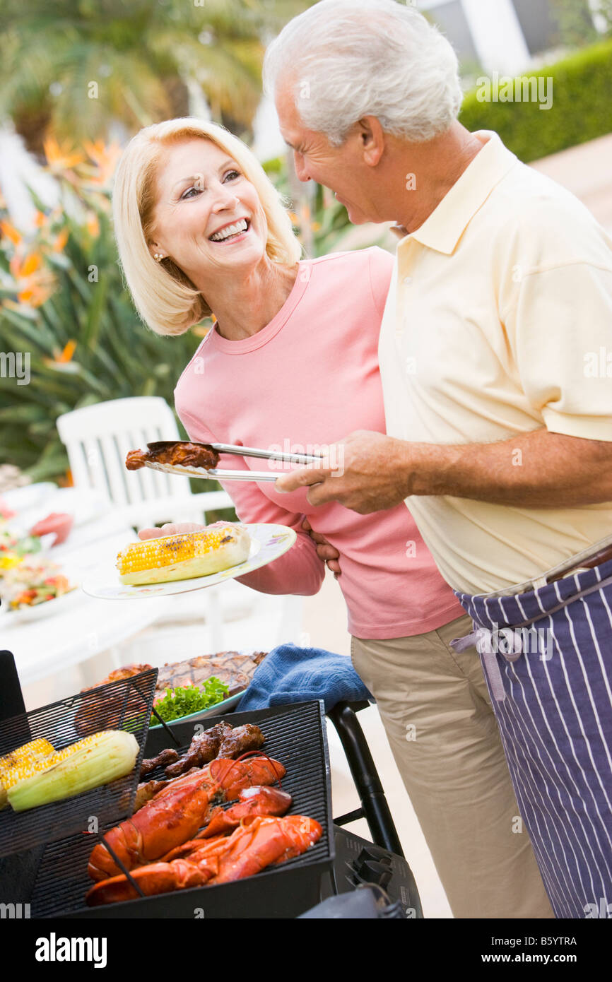 Couple Cooking On A Barbeque Stock Photo - Alamy