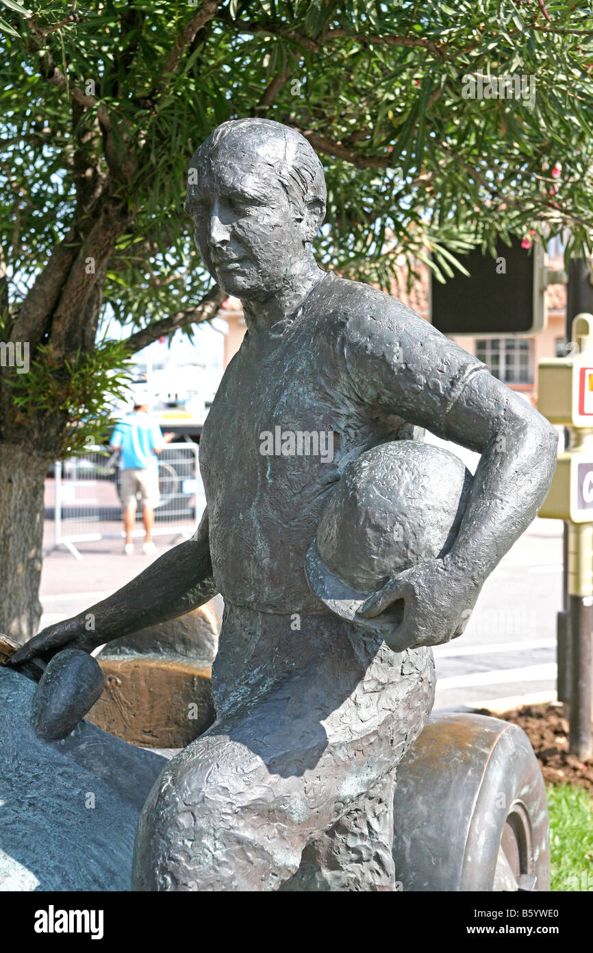 Bronze statue of Juan Manuel Fangio standing alongside his grand prix ...