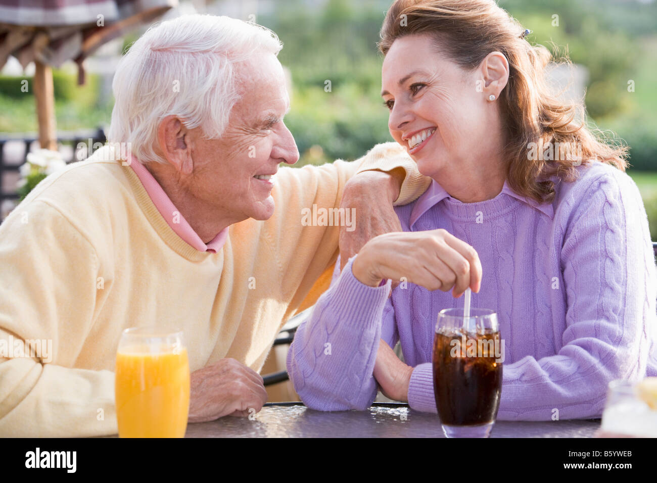 Couple Enjoying A Beverage By A Golf Course Stock Photo - Alamy