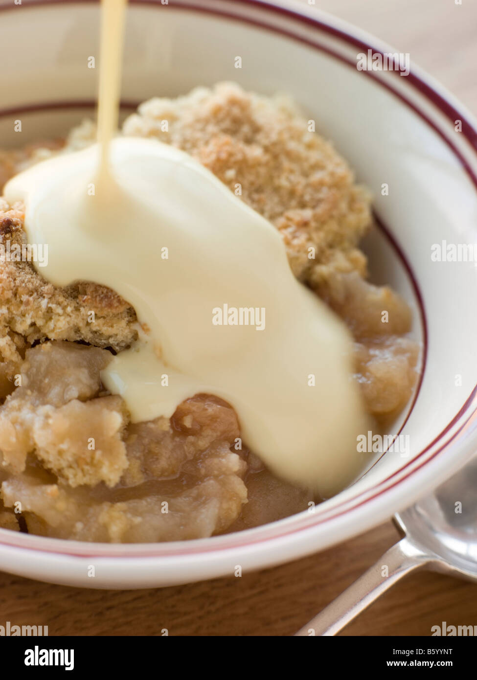 Bowl of Apple Crumble with Custard Stock Photo - Alamy