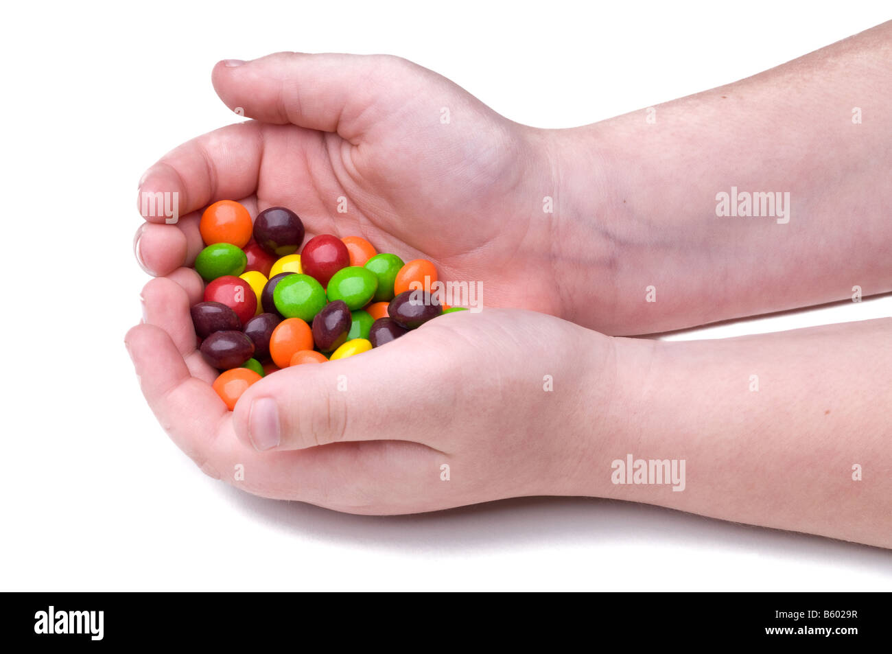 A childs cupped hands holding candy Stock Photo - Alamy