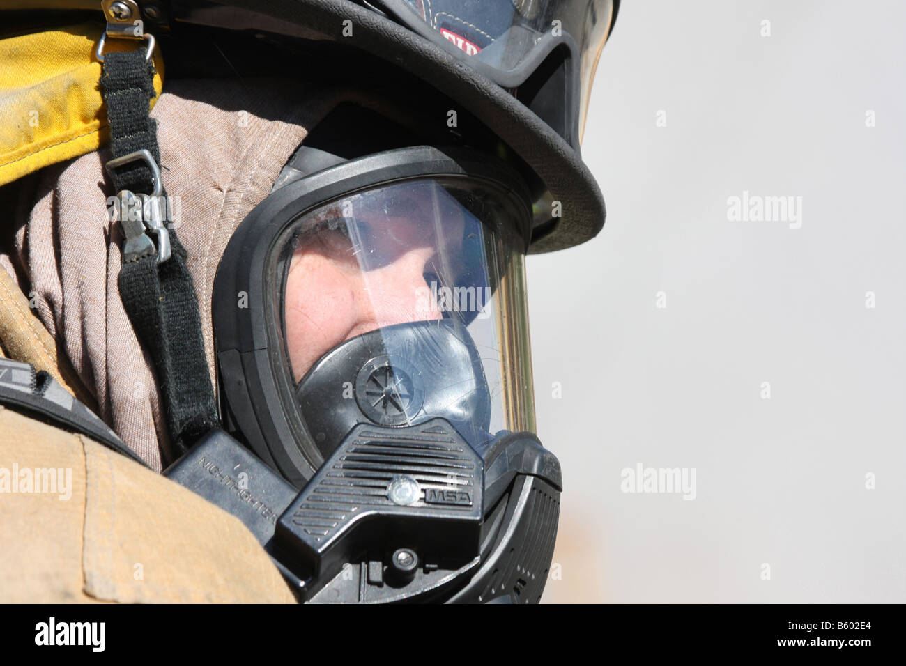 A close up of a firefighter peering through his breathing mask to see ...