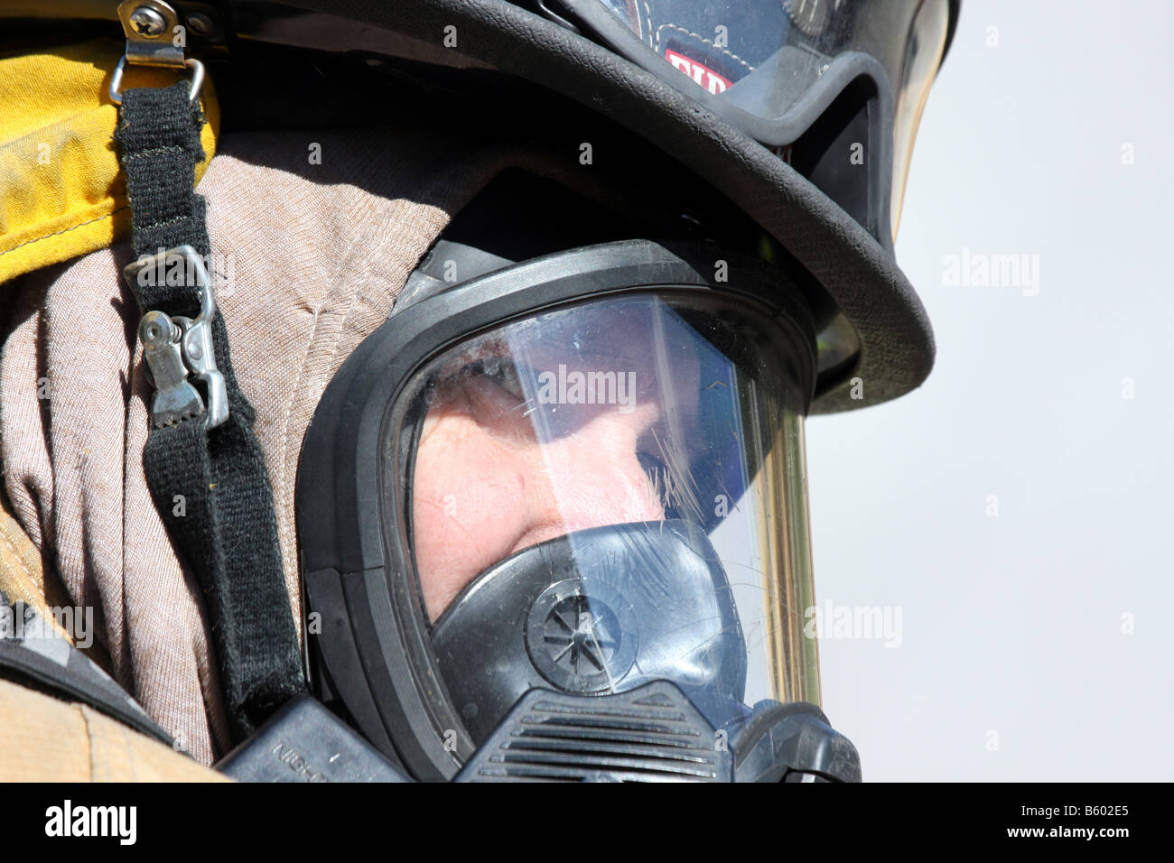 A close up of a firefighter peering through his breathing mask to see ...