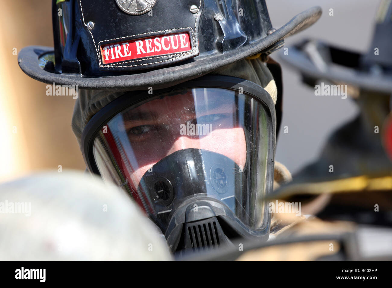 A close up of a firefighter peering through his breathing mask to see ...