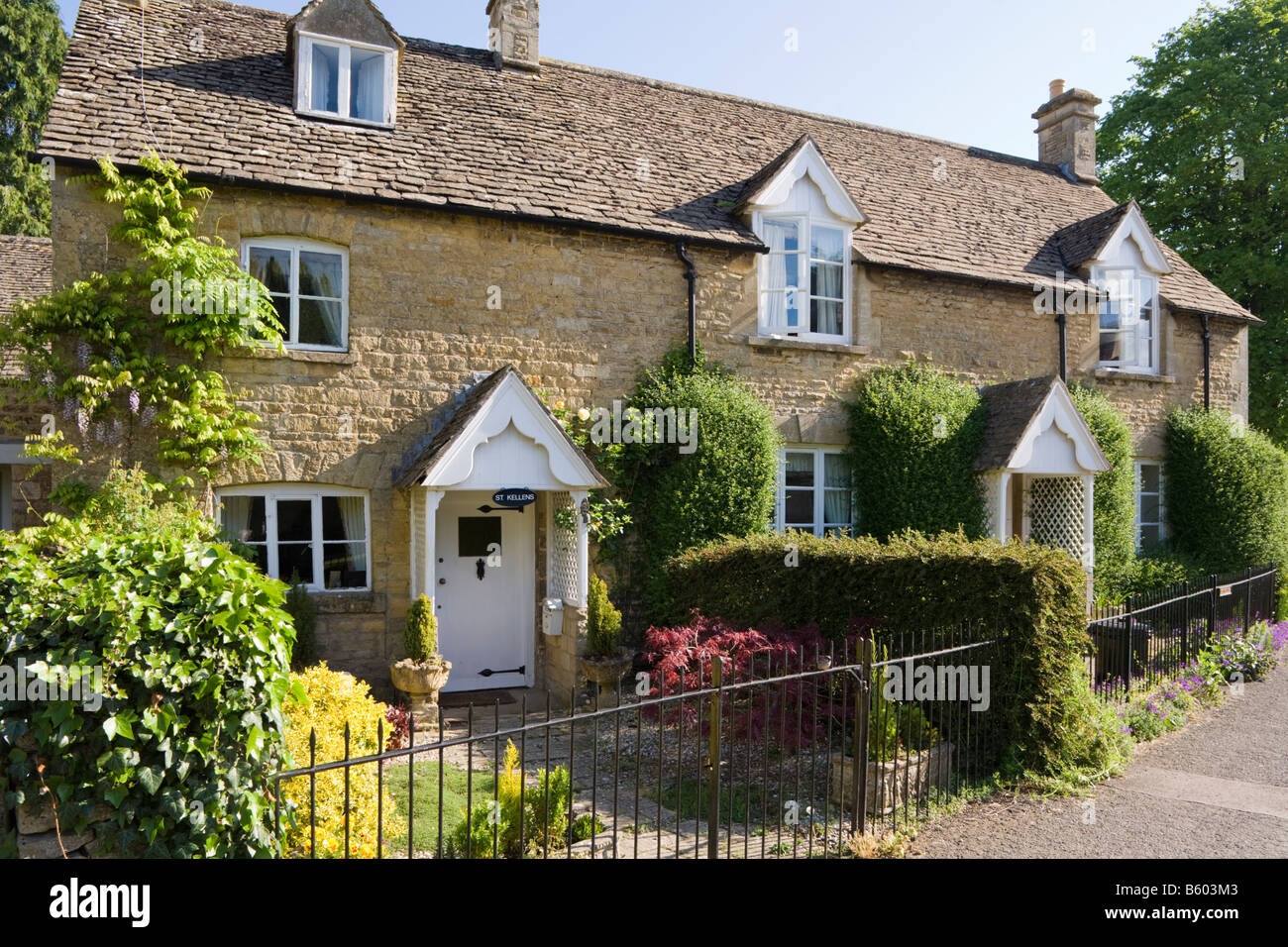 Early morning sunlight on old stone cottages in the Cotswolds village ...