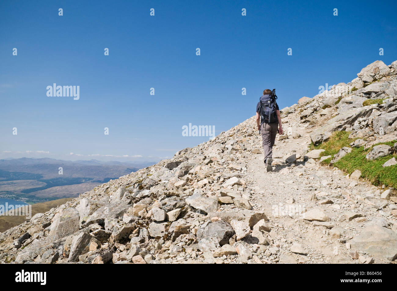 Single female hiker hikes rocky pony route trail towards summit of Ben ...