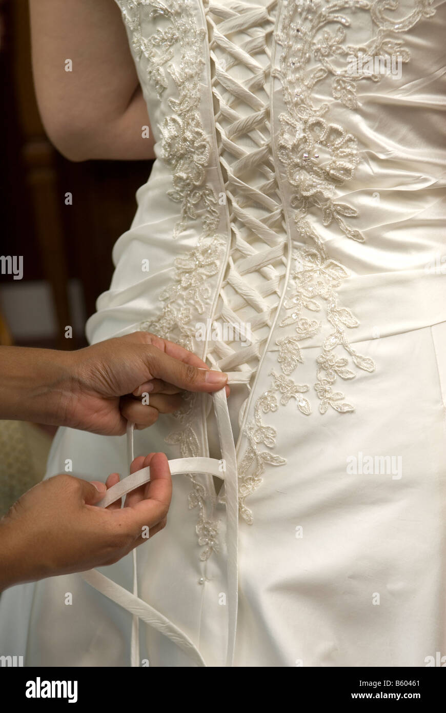 Bride being laced up in her wedding gown Stock Photo - Alamy
