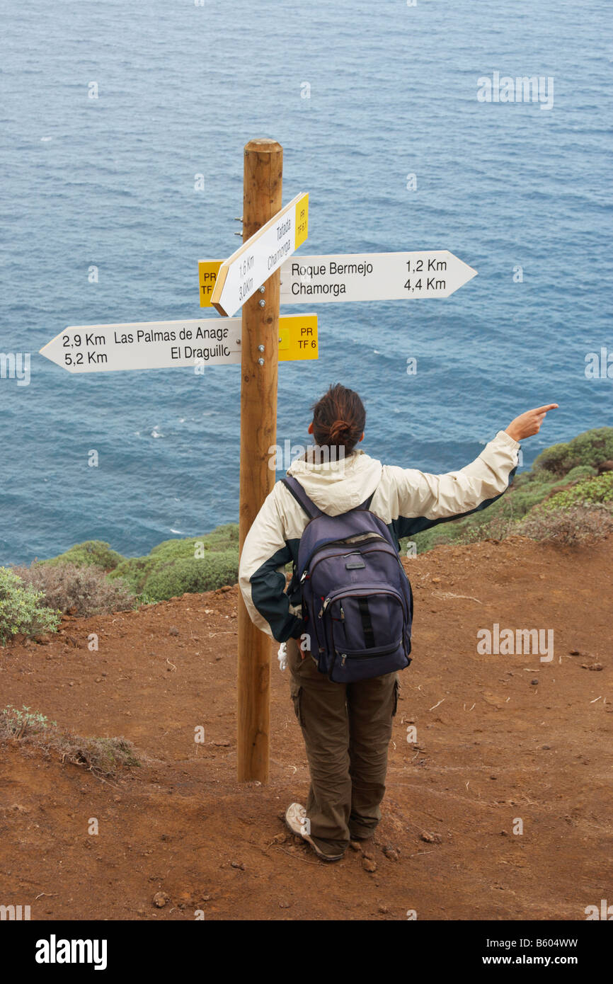 Female hiker reading footpath signs on coastal path in the Anaga ...