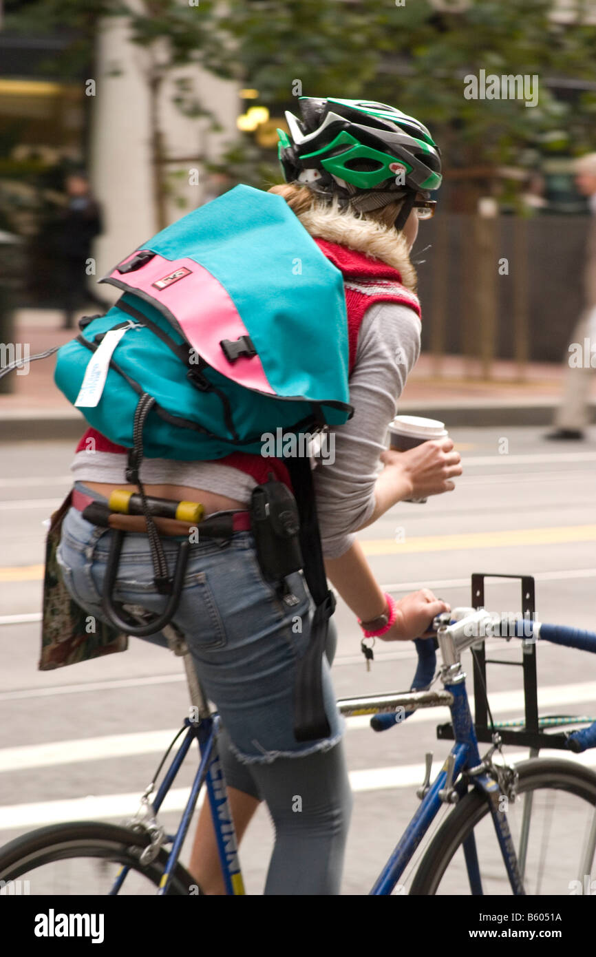 Female rider with a cup of Starbucks in her hand on city street Stock ...
