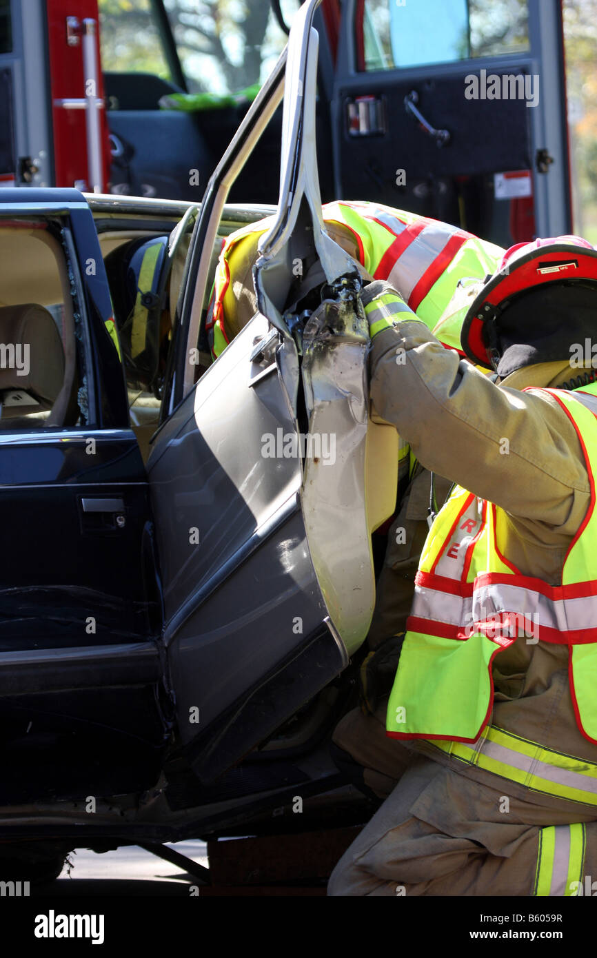 Firefighters doing extrication on a car by removing the car door Stock ...