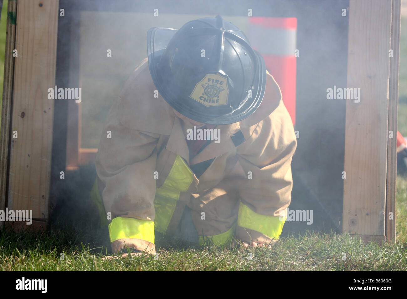 A little boy wearing a firemens jacket and fire chief hat at a Fire ...