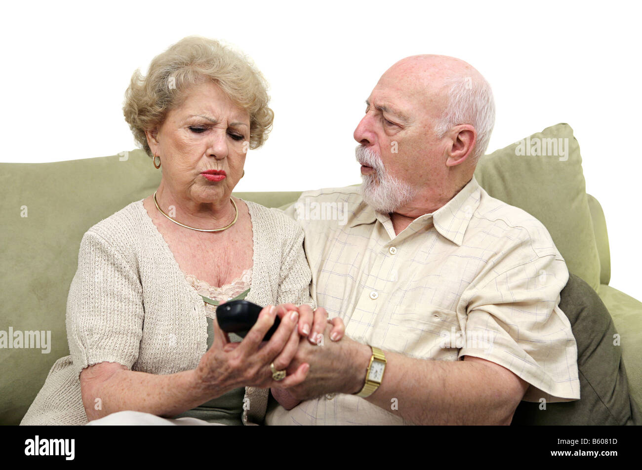A senior couple fighting over the television remote control White ...