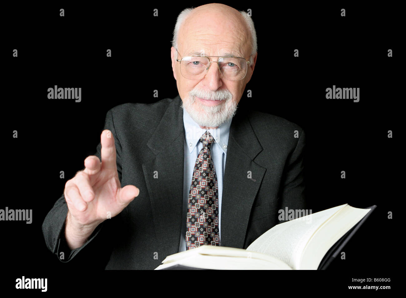 A handsome older man either teaching or preaching from a book Isolated ...