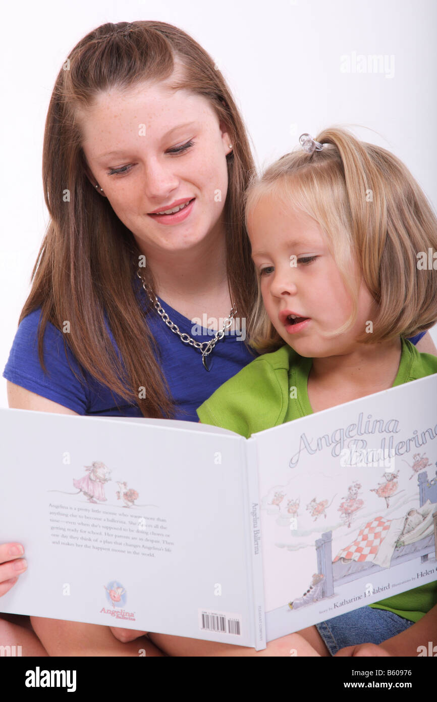 A teenager and child are reading a book together Stock Photo - Alamy