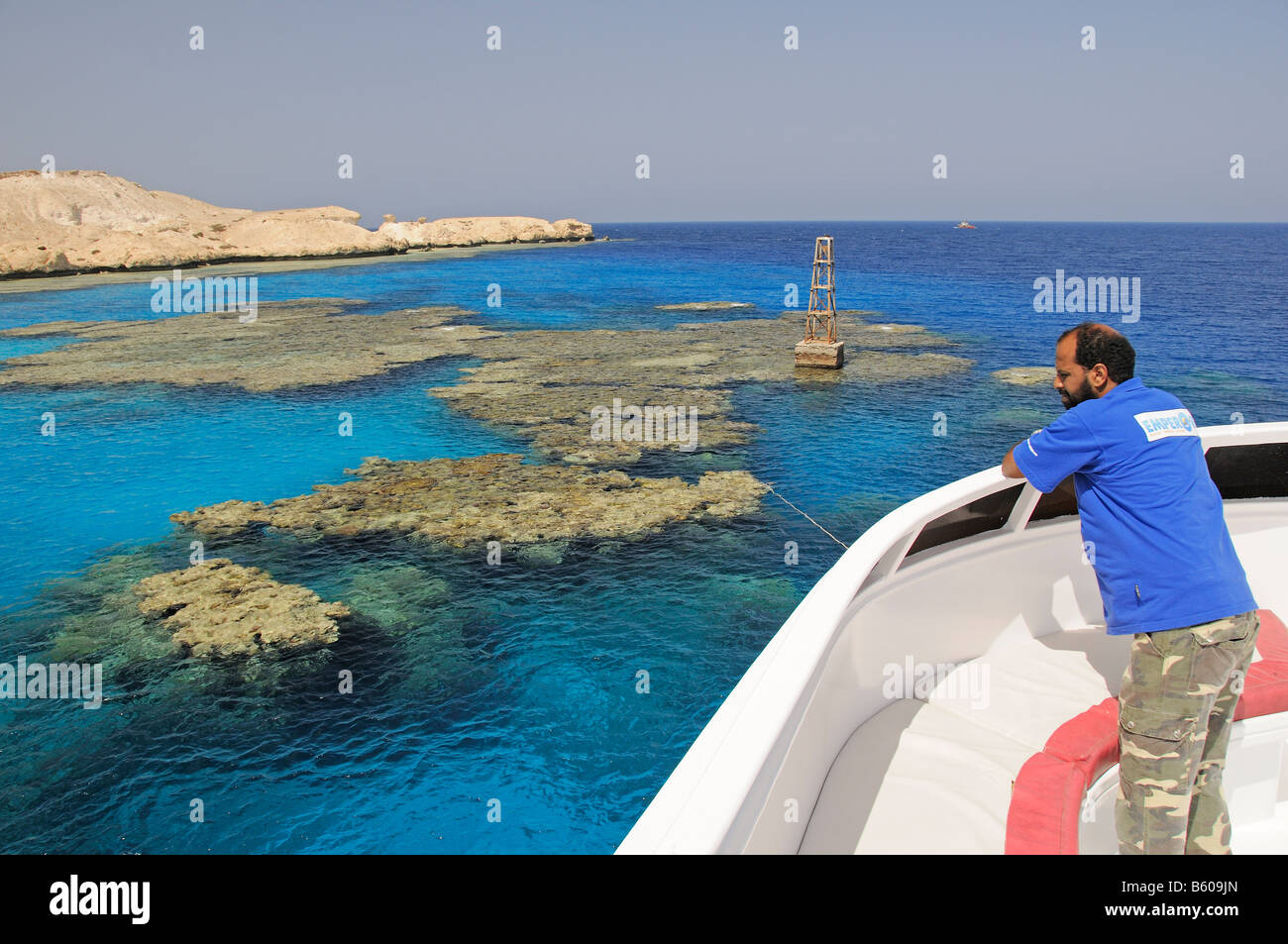man on boat watching coral reefs Stock Photo - Alamy