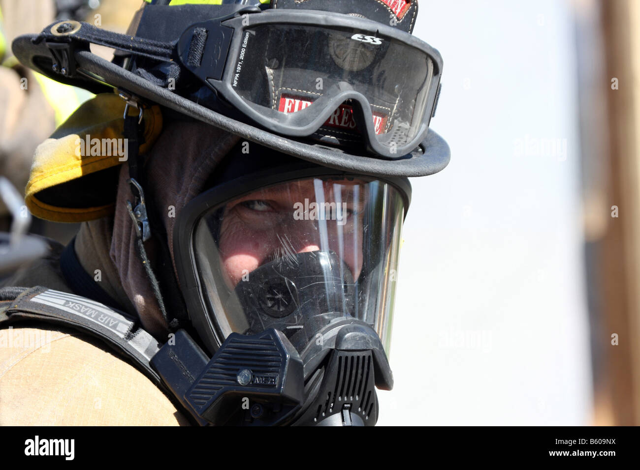 A close up of a firefighter peering through his breathing mask to see ...