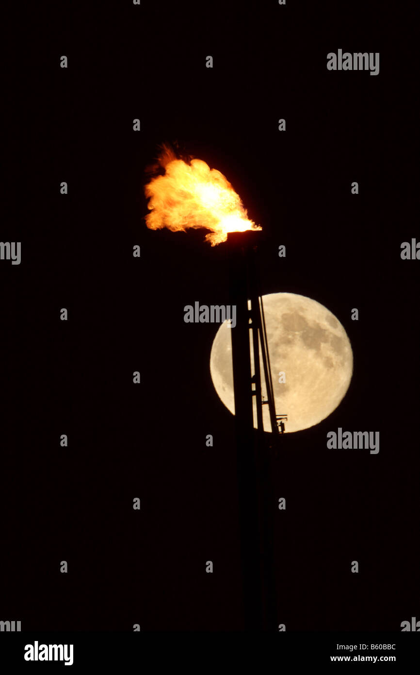 Full moon behind natural gas flame Stock Photo - Alamy