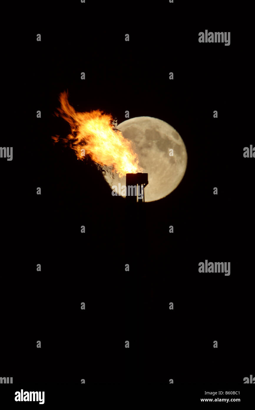Full moon behind natural gas flame Stock Photo - Alamy