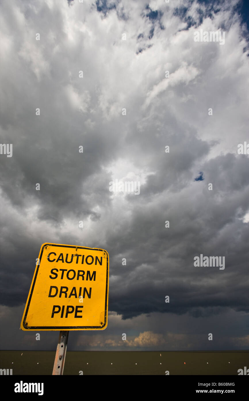 Caution sign on the sandy shores of Lake Winnipeg with threatening ...