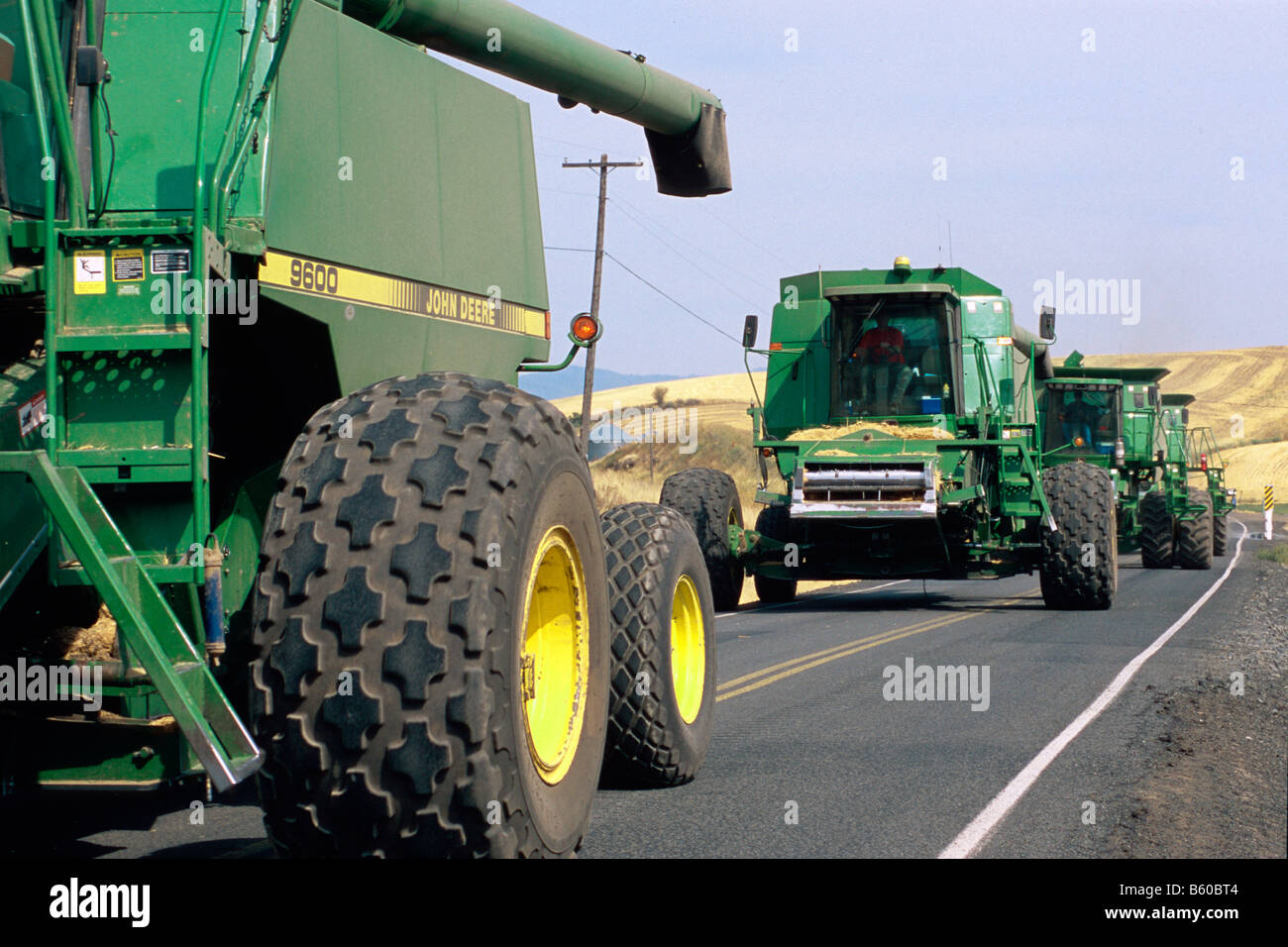 A team of combines with headers removed on the road headed for a new ...