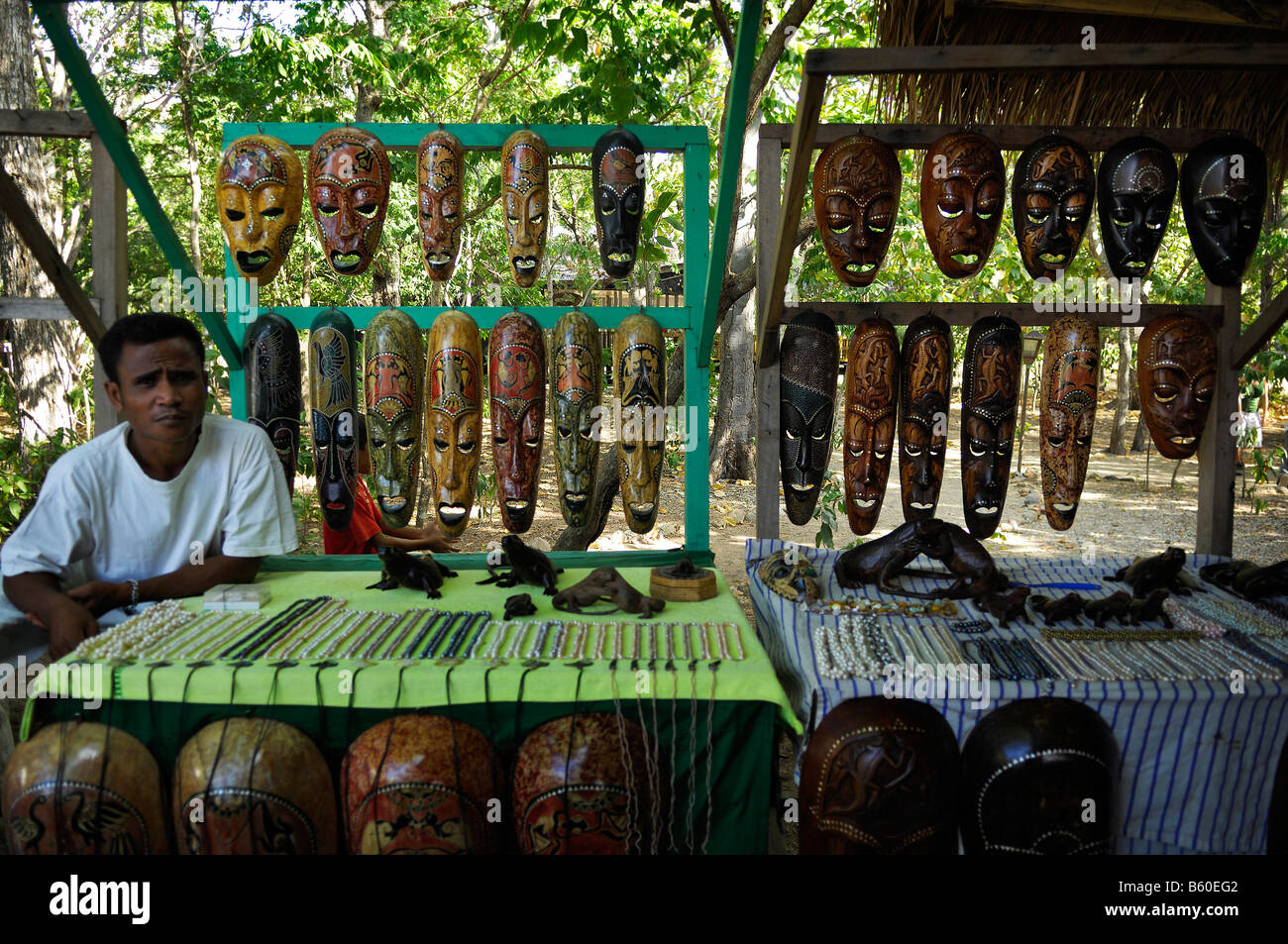Man sitting behind a sales booth selling masks and perls, Komodo ...
