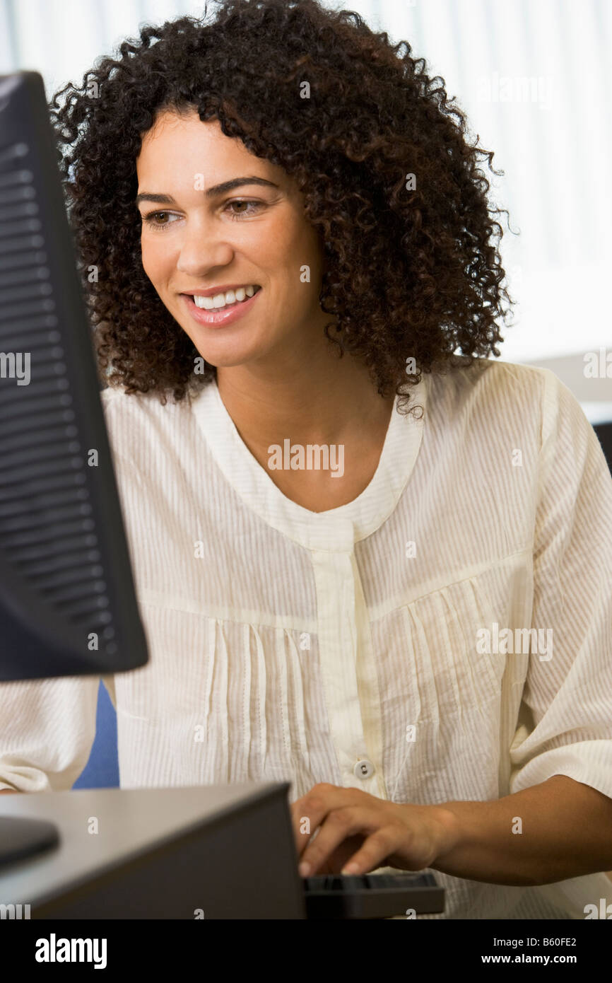 Woman sitting at a computer terminal typing (high key Stock Photo - Alamy