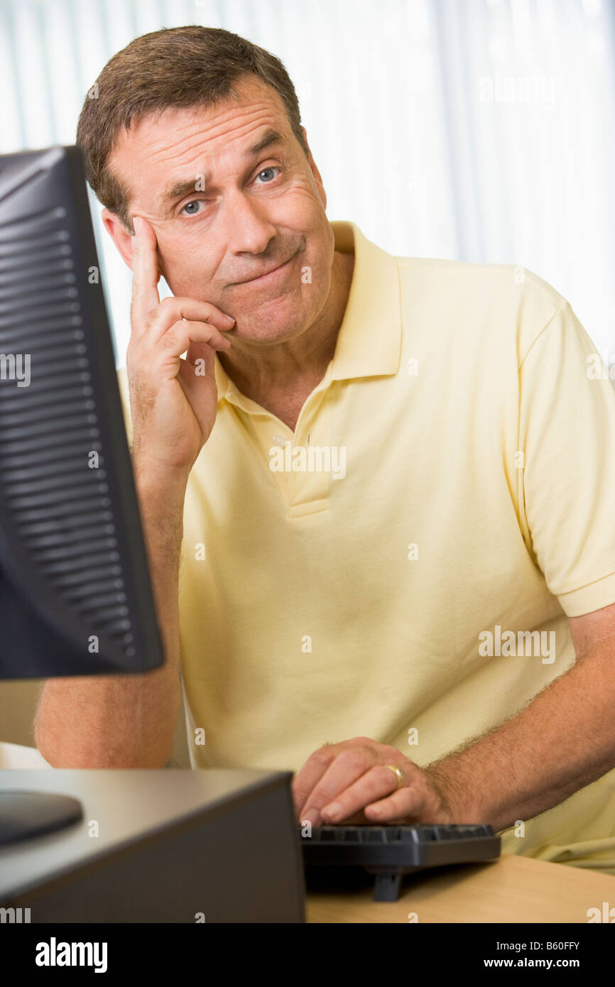 Man sitting at a computer terminal bored (high key Stock Photo - Alamy