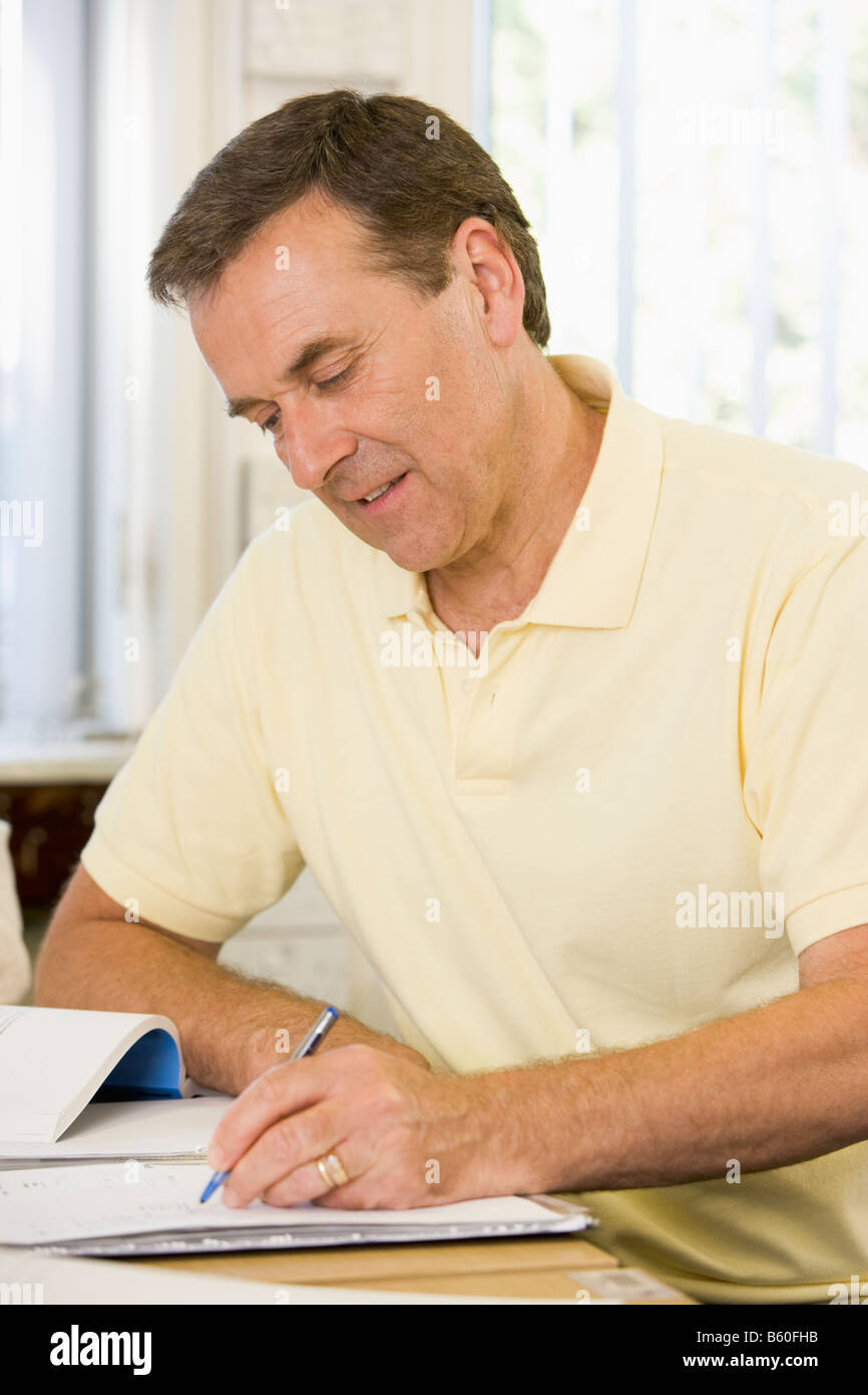 Portrait of a mature student taking notes with others in lecture in ...