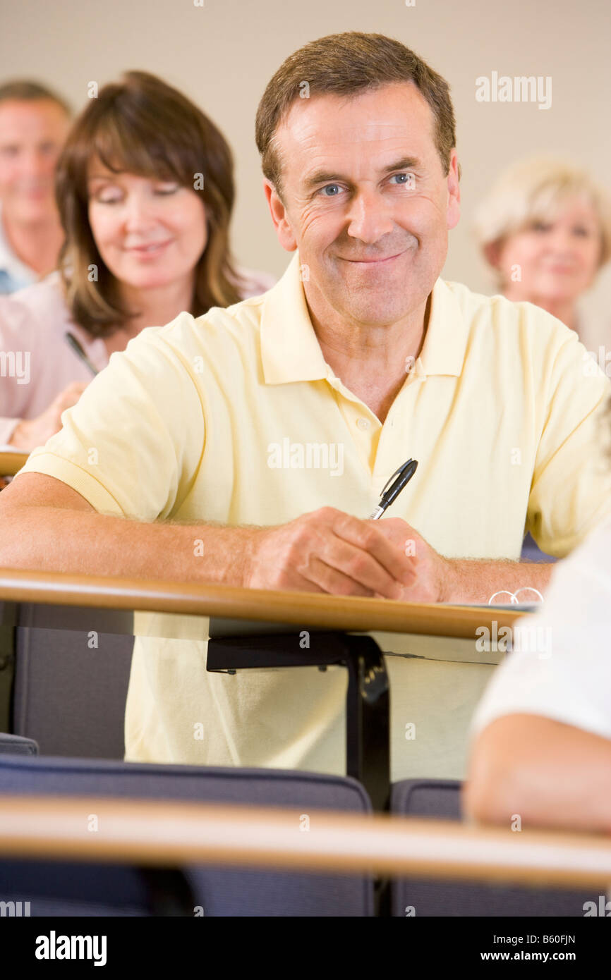 Man sitting in adult classroom with students in background (selective ...