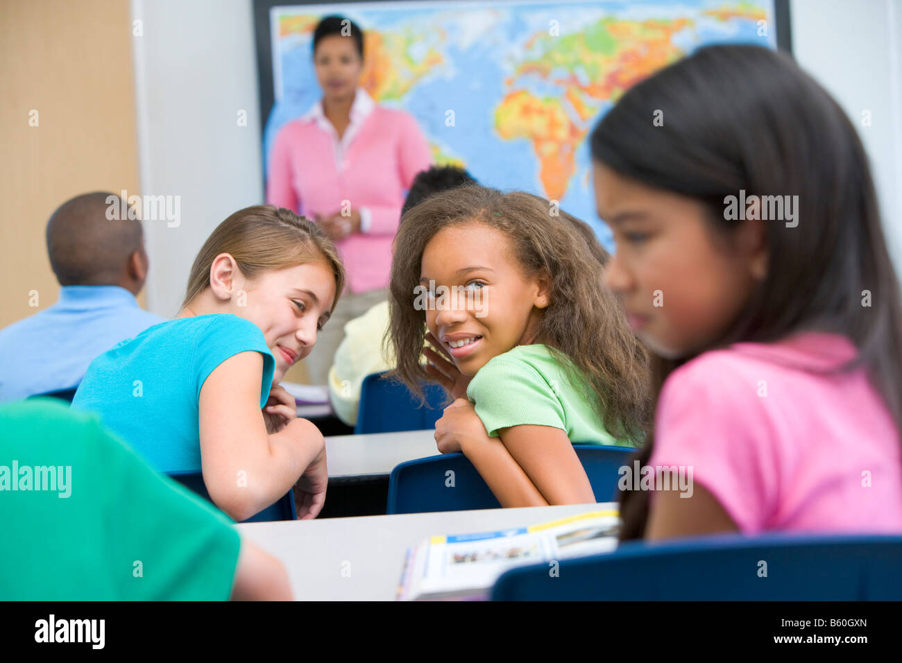 Students in class bullying student with teacher in background ...