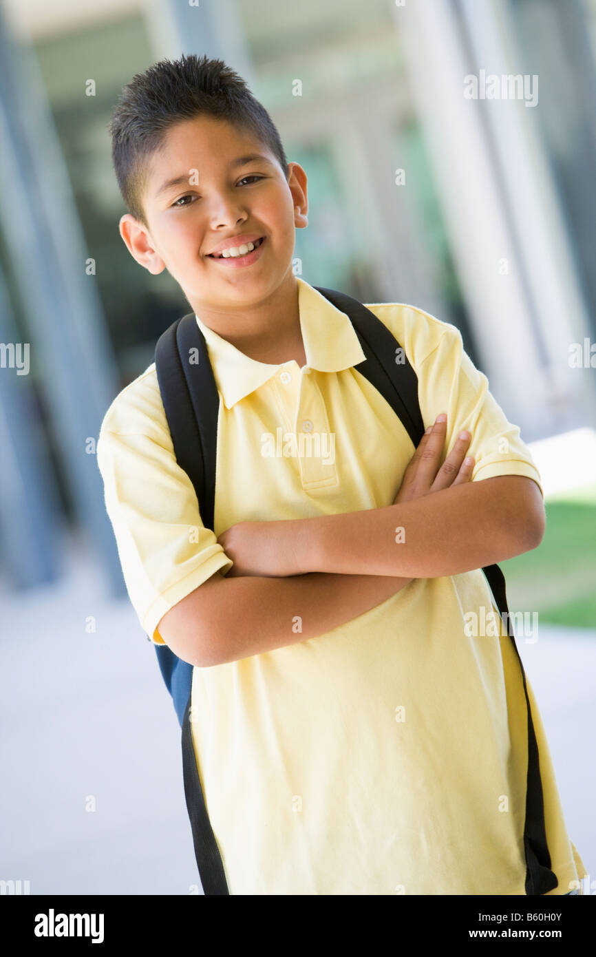 Student standing outside school smiling (selective focus Stock Photo ...