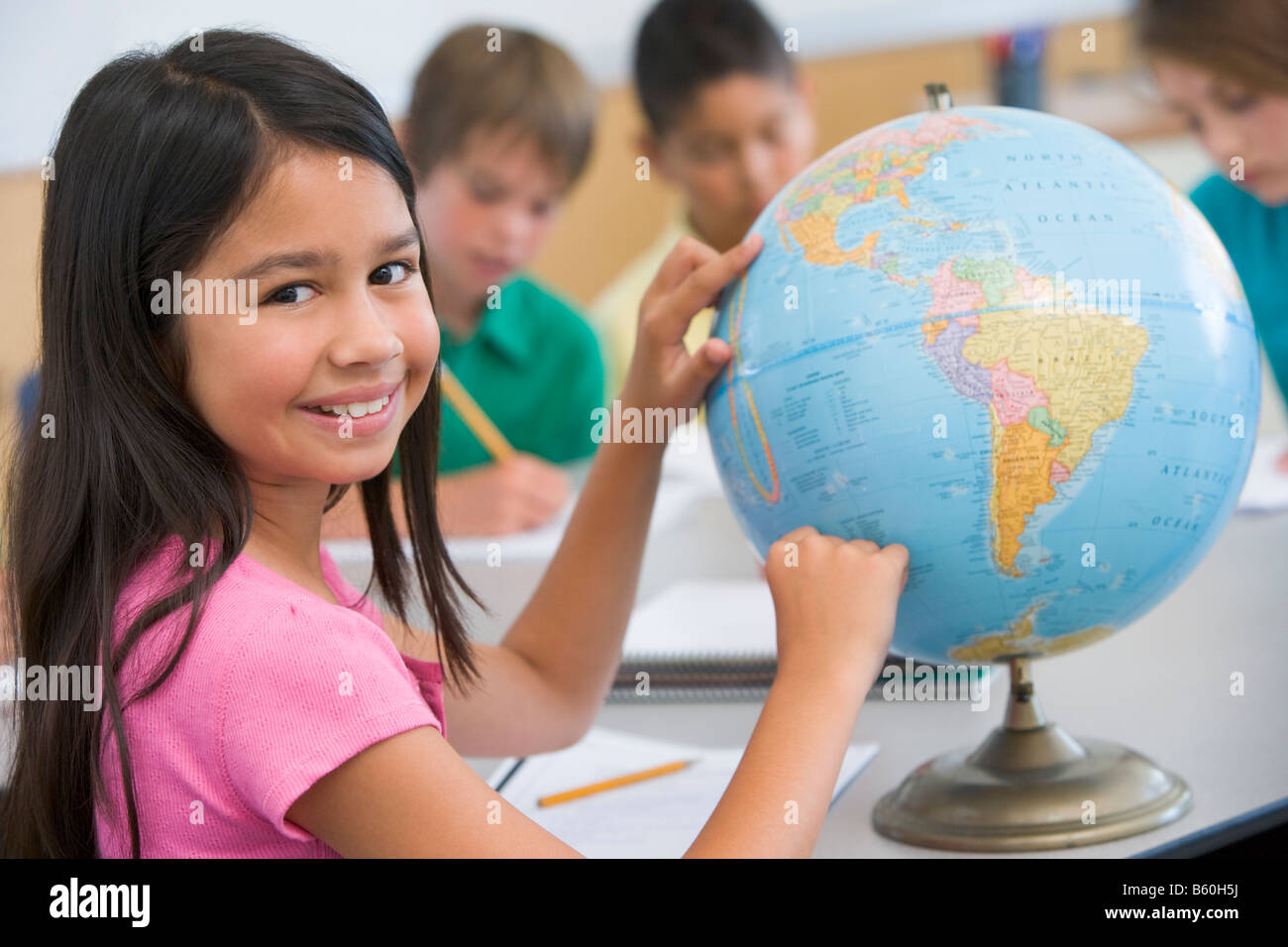 Student in class pointing at a globe (selective focus Stock Photo - Alamy