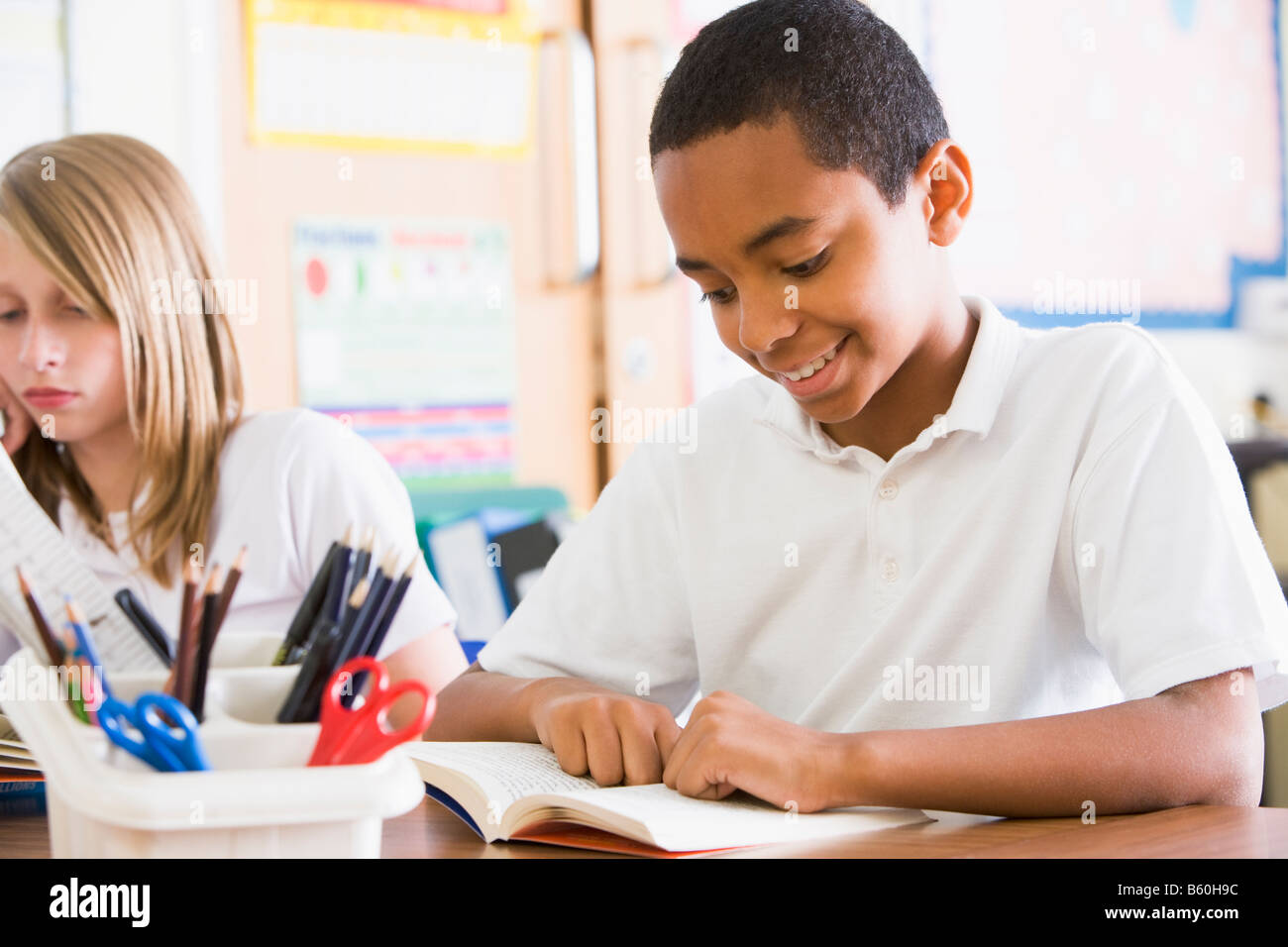 Student in class reading book Stock Photo - Alamy