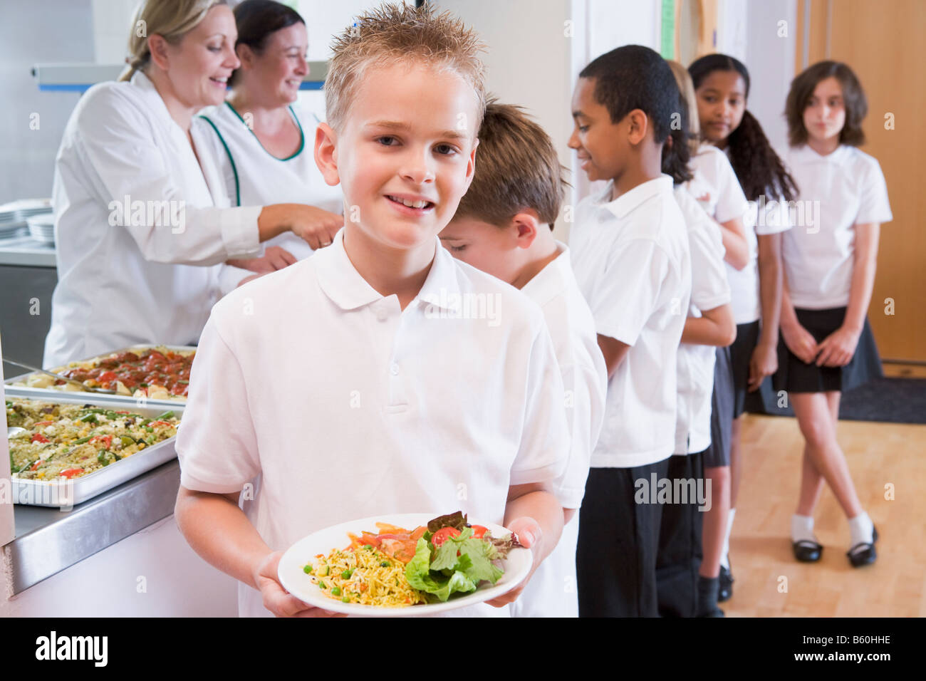 Students in cafeteria line with one holding his healthy meal and ...