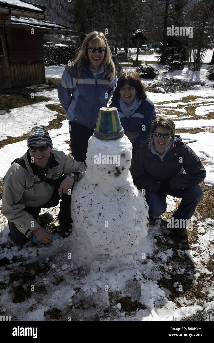 Friends with snowman Stock Photo - Alamy