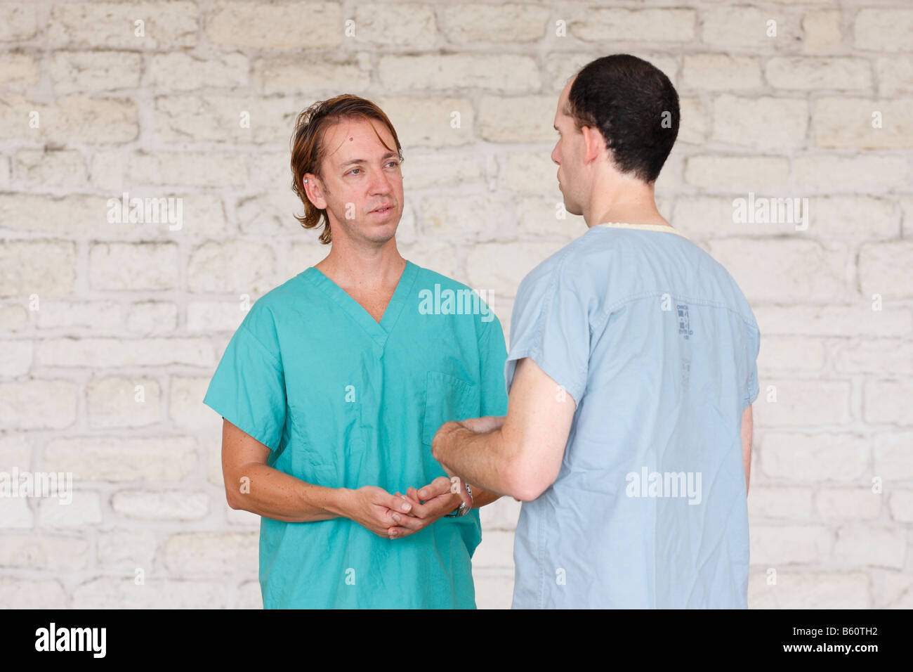 Two male nurses in scrubs talking Stock Photo - Alamy