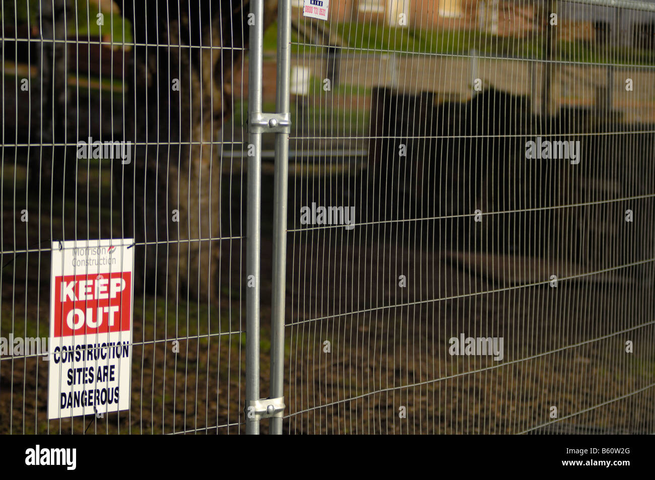 Fencing around building site with safety notice Stock Photo - Alamy